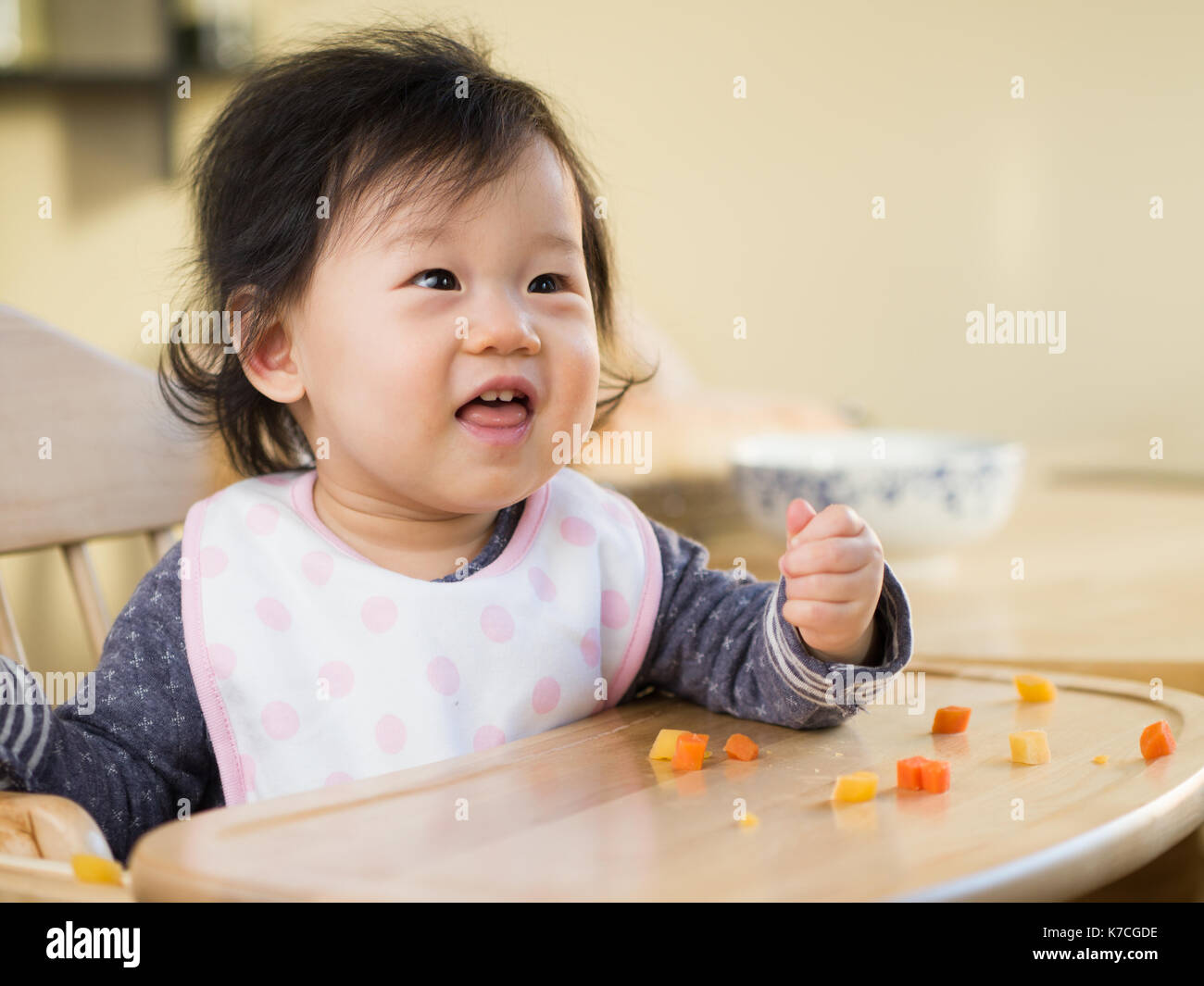 baby girl eating vegetable first time at home Stock Photo - Alamy