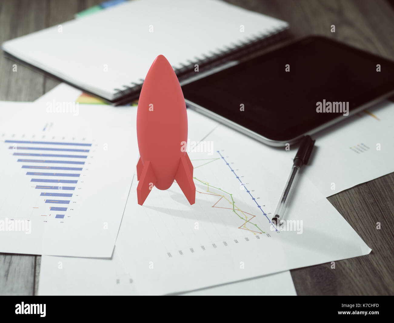 rocket model on desk with pie chart Stock Photo - Alamy