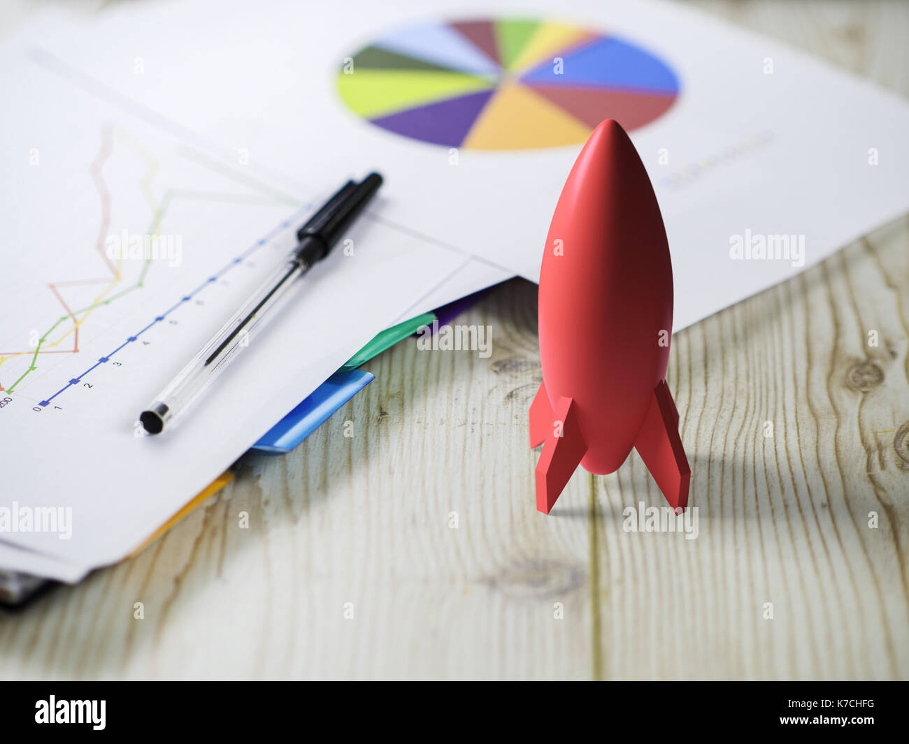 rocket model on desk with pie chart Stock Photo - Alamy
