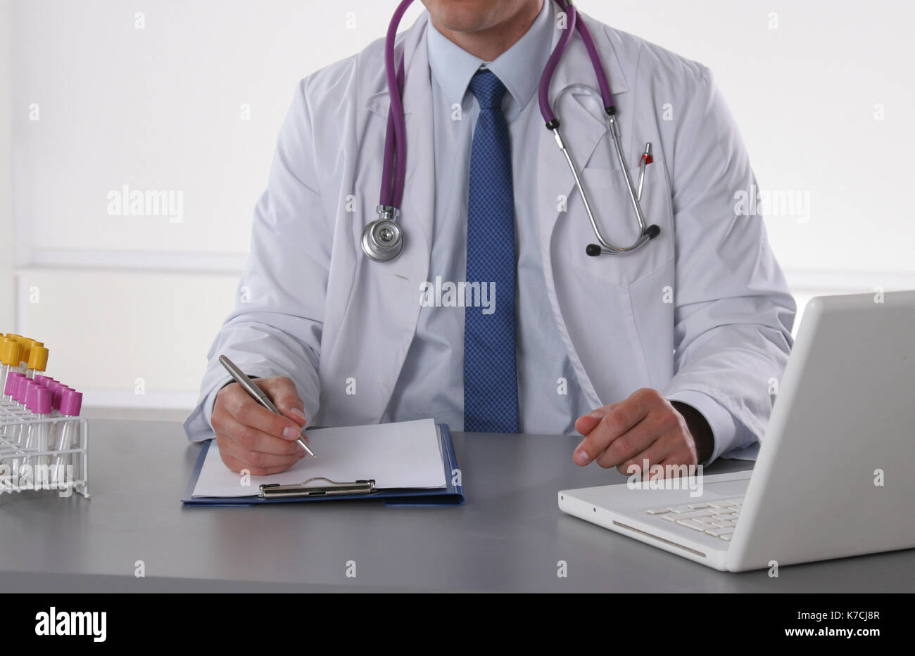 Male doctor write on the desk with test tube Stock Photo - Alamy