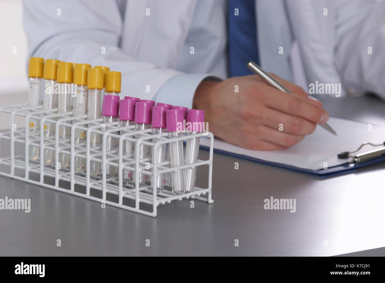 Male doctor write on the desk with test tube Stock Photo - Alamy