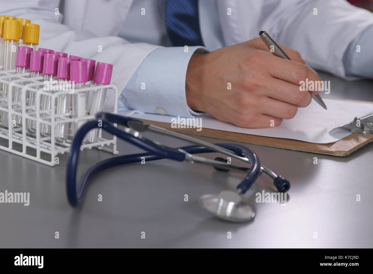 Male doctor write on the desk with test tube Stock Photo - Alamy