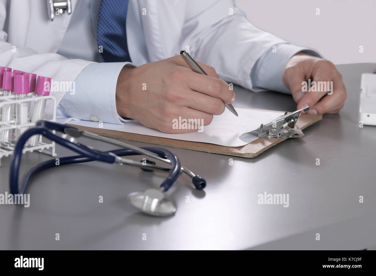 Male doctor write on the desk with test tube Stock Photo - Alamy