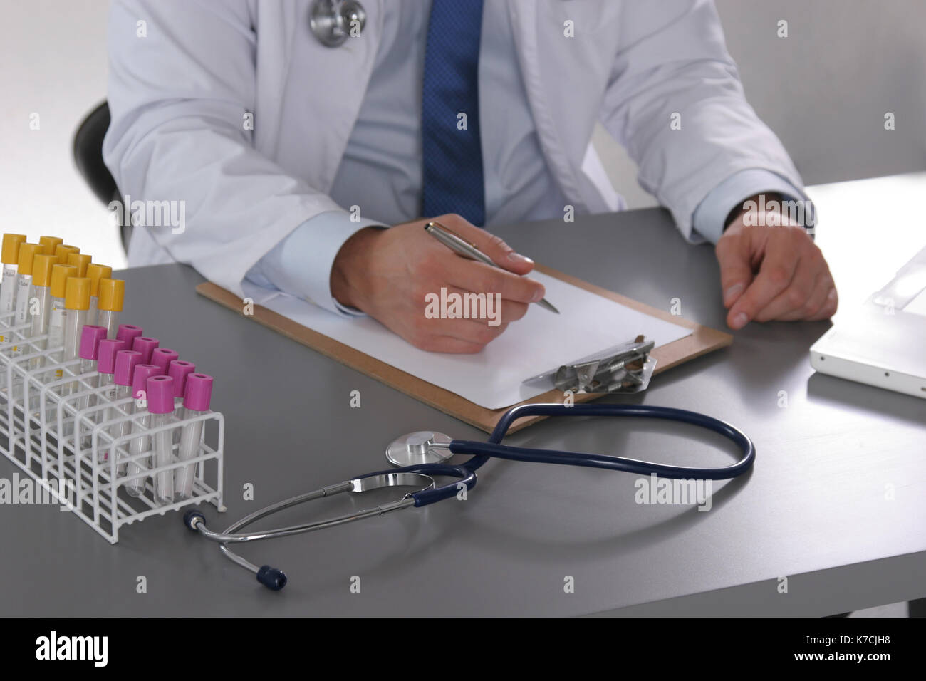Male doctor write on the desk with test tube Stock Photo - Alamy