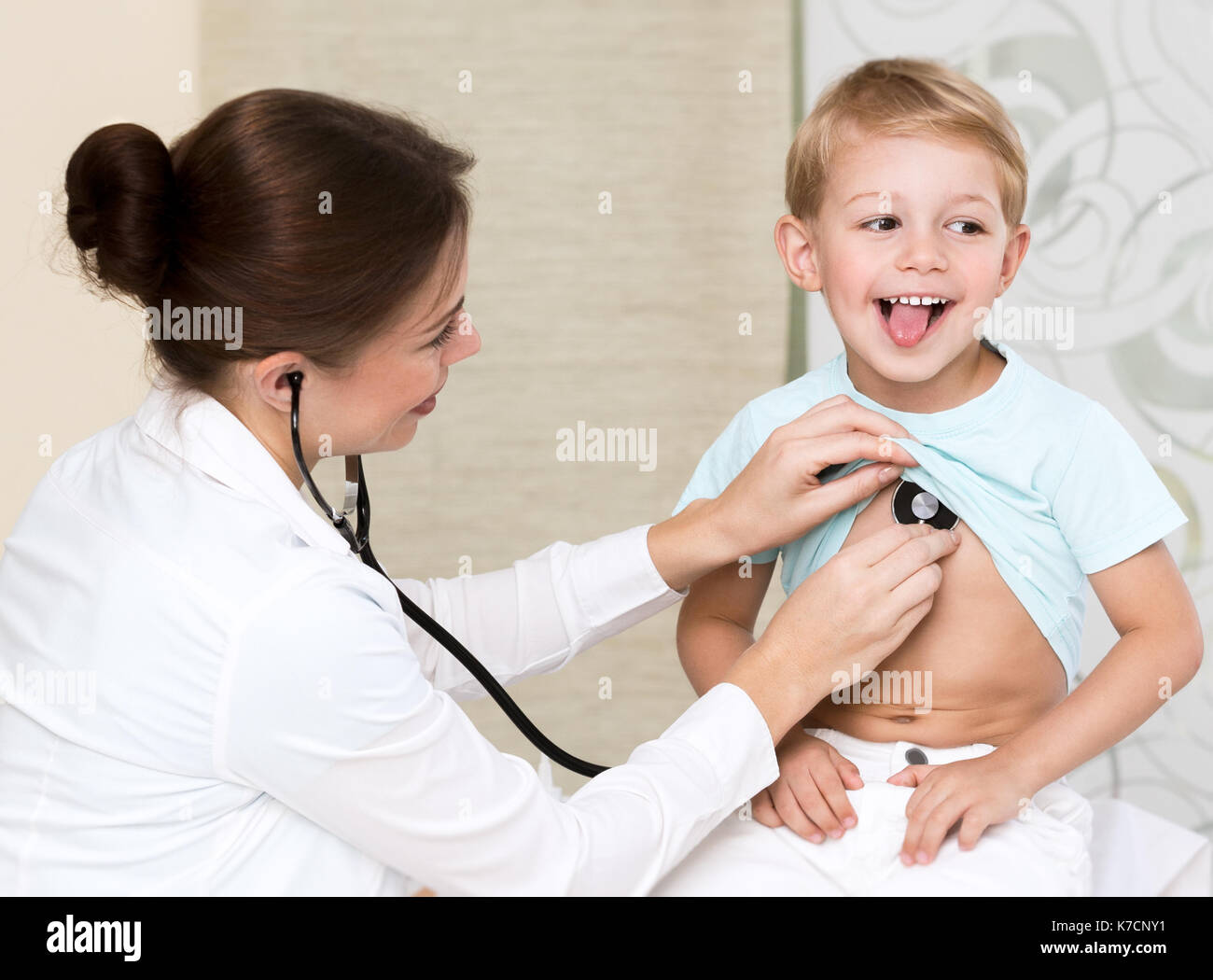 Sweet child visiting doctor, beautiful young specialist examines the ...