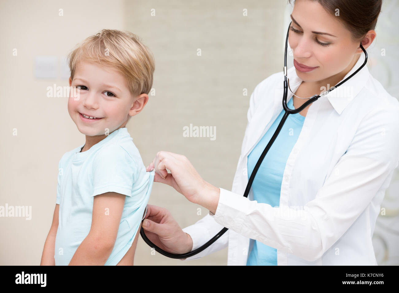 Cute little boy with pleasure visiting pediatrician, scheduled check up ...