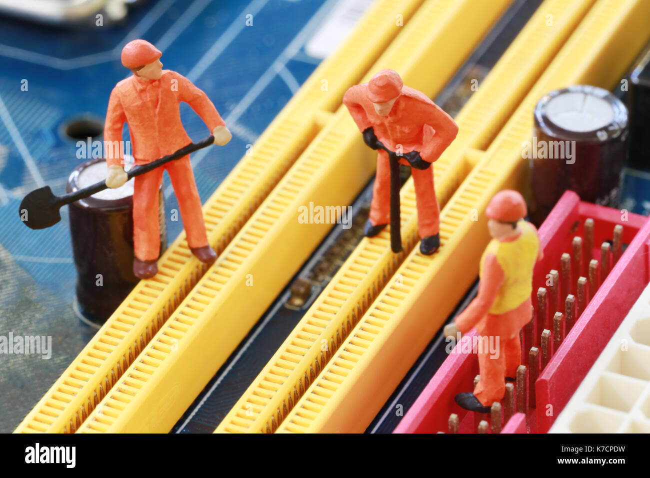Idea of a worker is miners are digging for ore on computer mainboard in ...