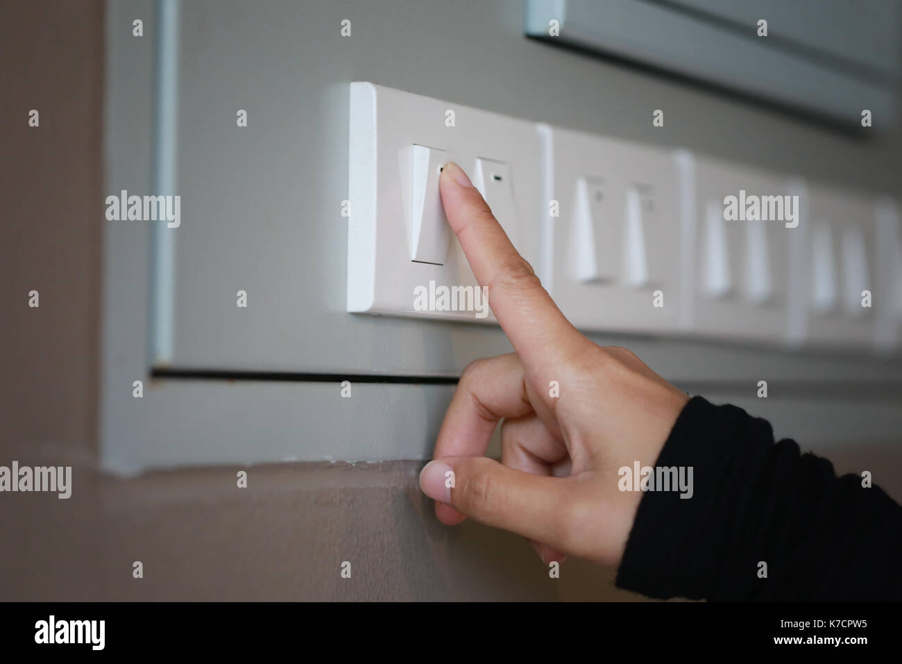 fingers are turning off light switch in the house,concept for energy ...