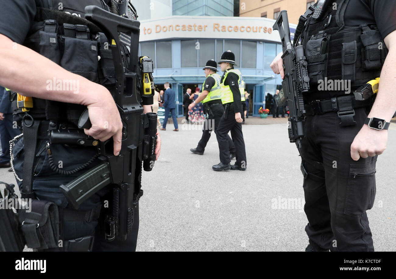 Armed Police stand at the main entrance of Doncaster Racecourse, before ...