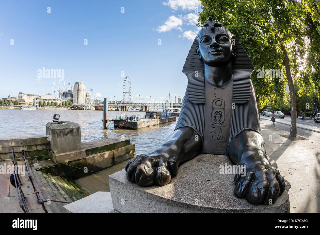A bronze sphinx on the banks of the Thames with the London Eye in the ...