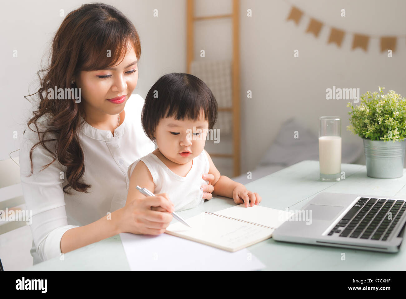 Mother and daughter are learning to write Stock Photo - Alamy