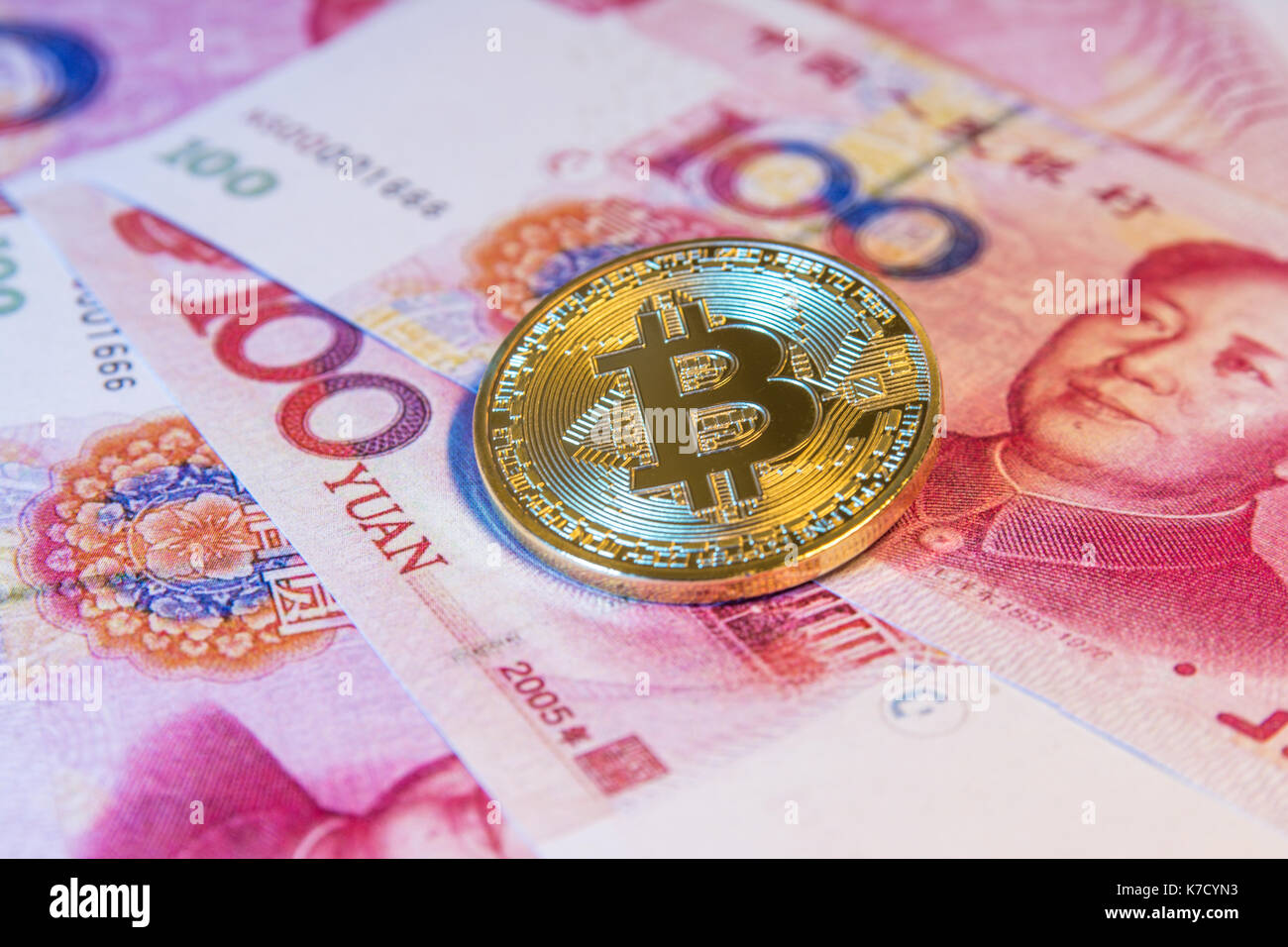 Financial concept with golden Bitcoin on 100 yuan or renminbi banknote ...
