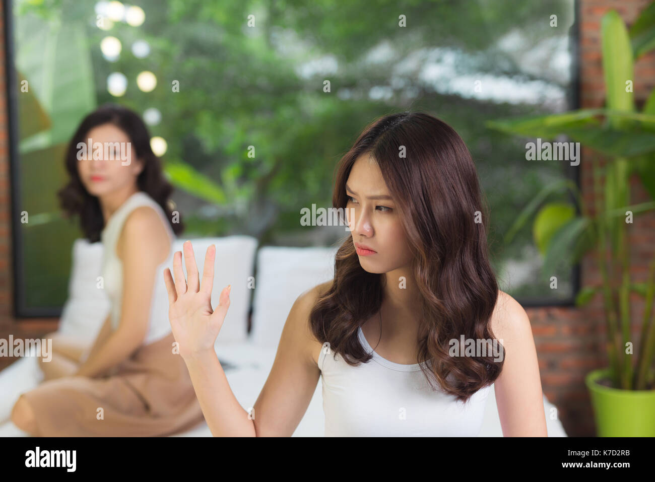 Two friends not talking to each other after fight on bed in sitting ...