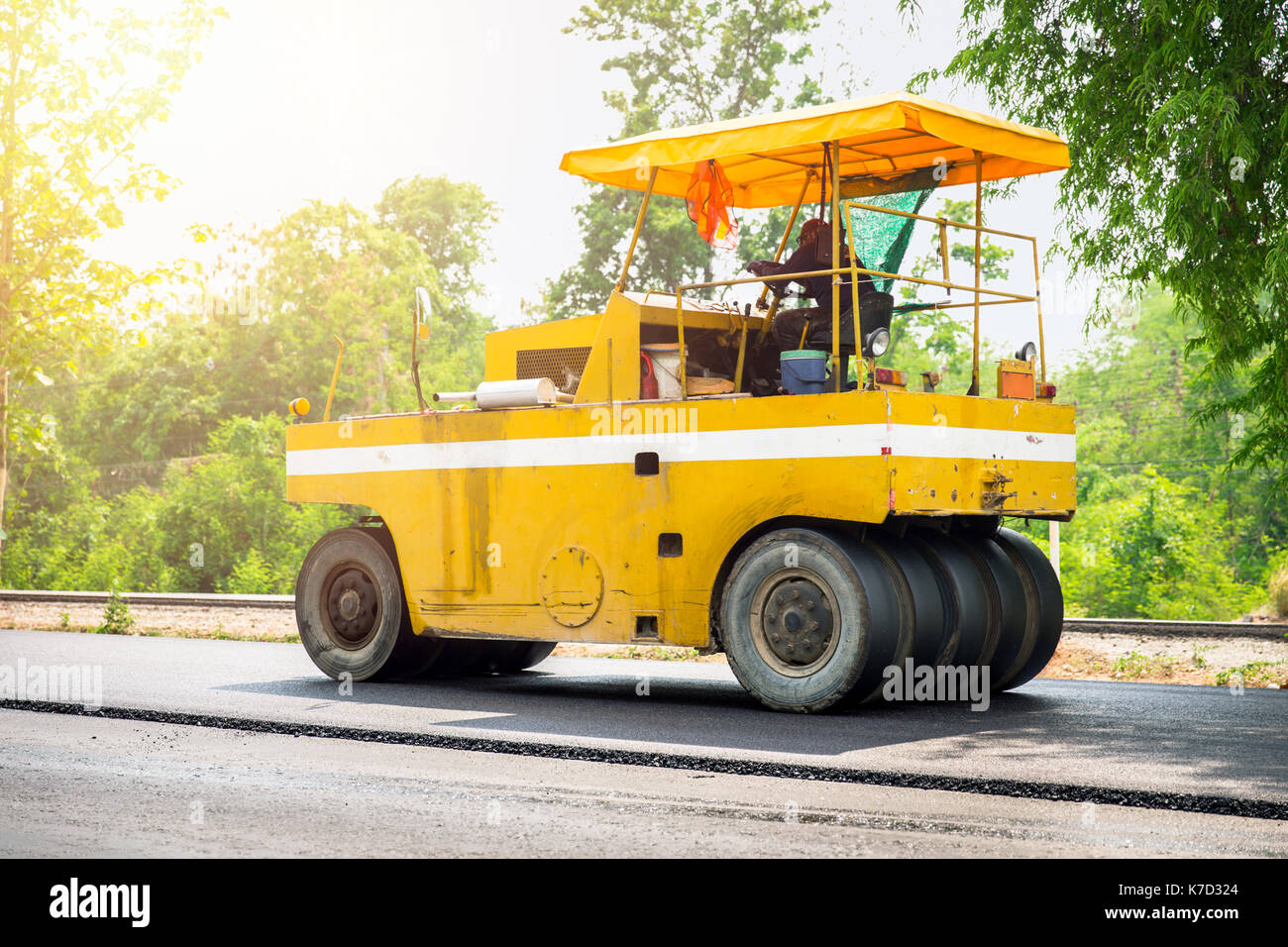 asphalt road construction with machine and steamroller truck at freeway ...