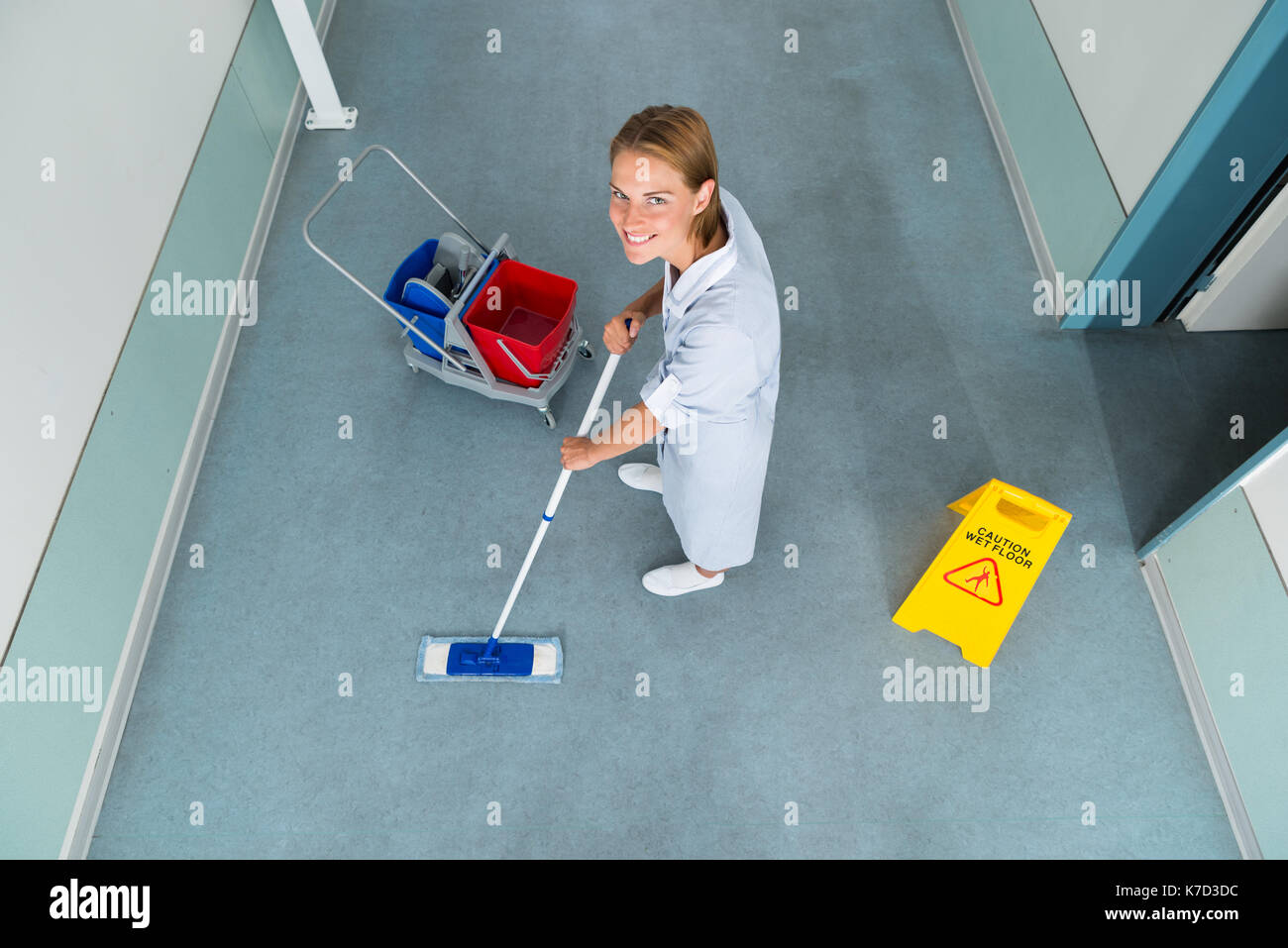 High Angle View Of Janitor With Mop Cleaning Floor Of Corridor Pass ...