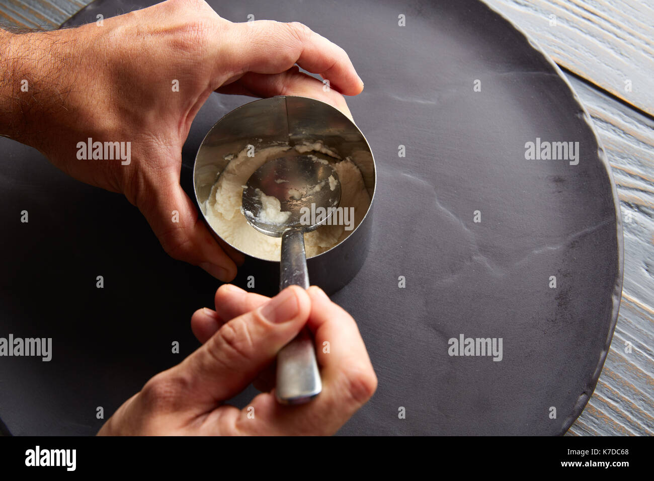 pannacotta preparation with chef hands on black slate dish Stock Photo ...