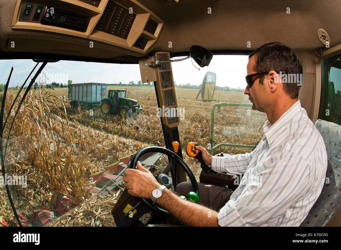 Driver of the combine, observes from the driving position, the tractor ...