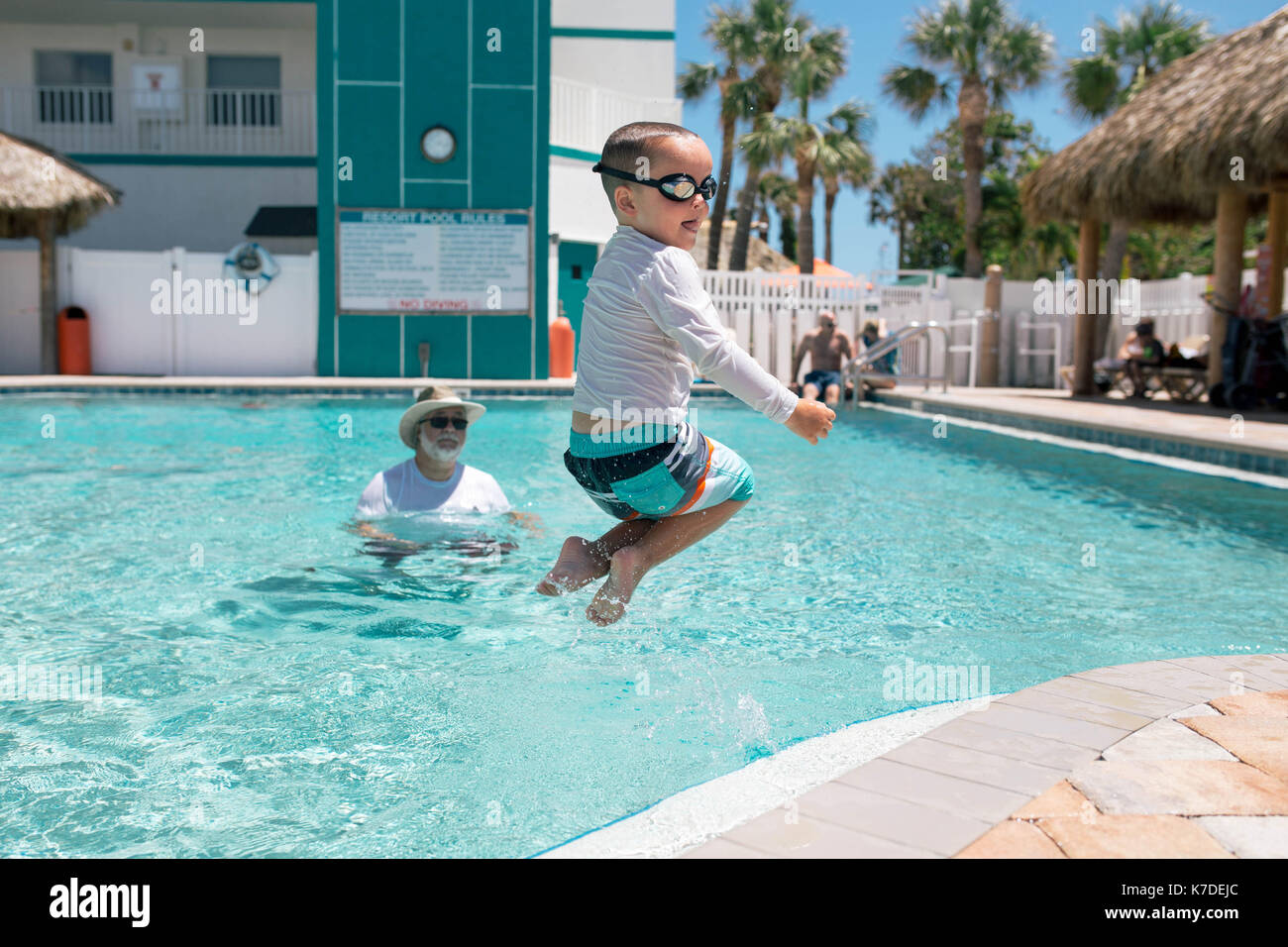 Playful boy jumping into swimming pool Stock Photo - Alamy