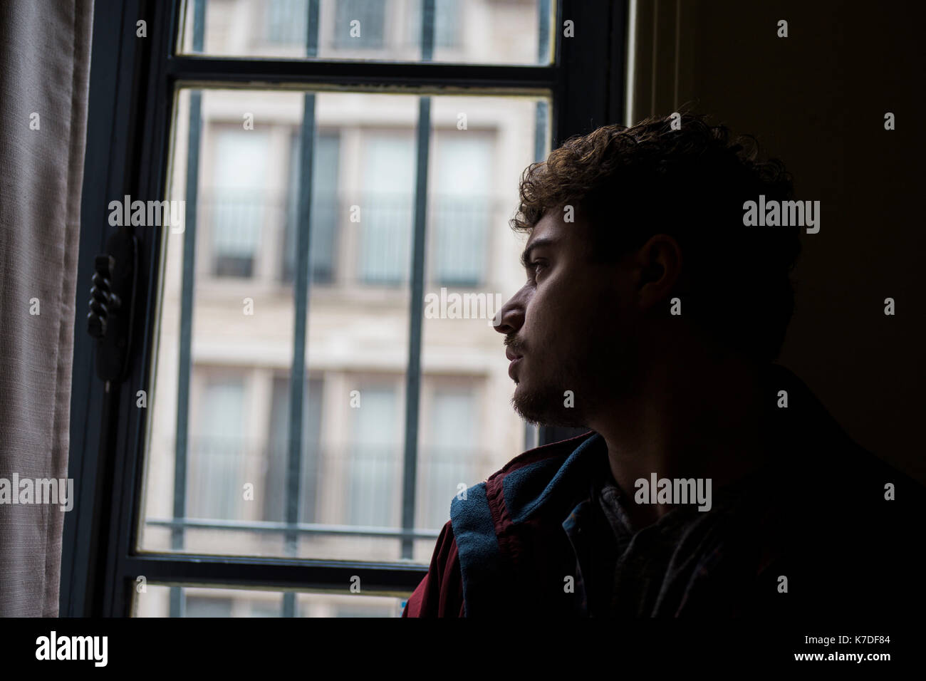 Close-up of thoughtful man looking through window Stock Photo - Alamy