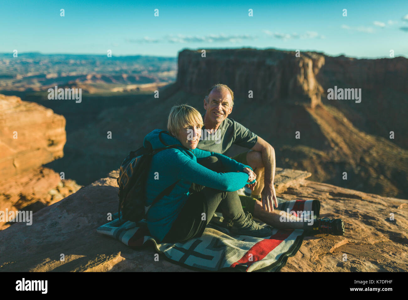Portrait of hiking couple sitting on mountain against rock formation at ...
