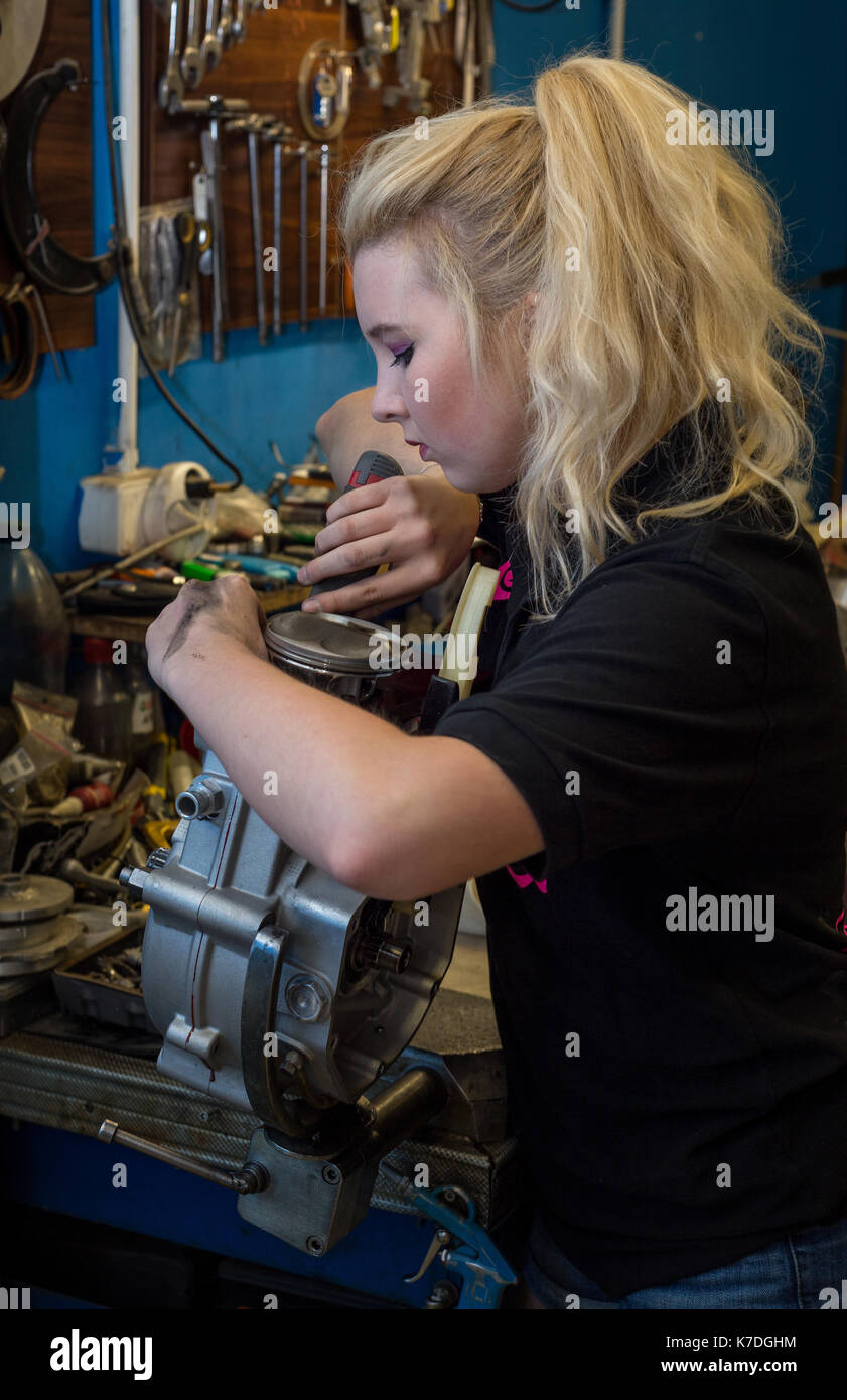 Breaking stereotypes - teenager girl working on broken motorcycle ...