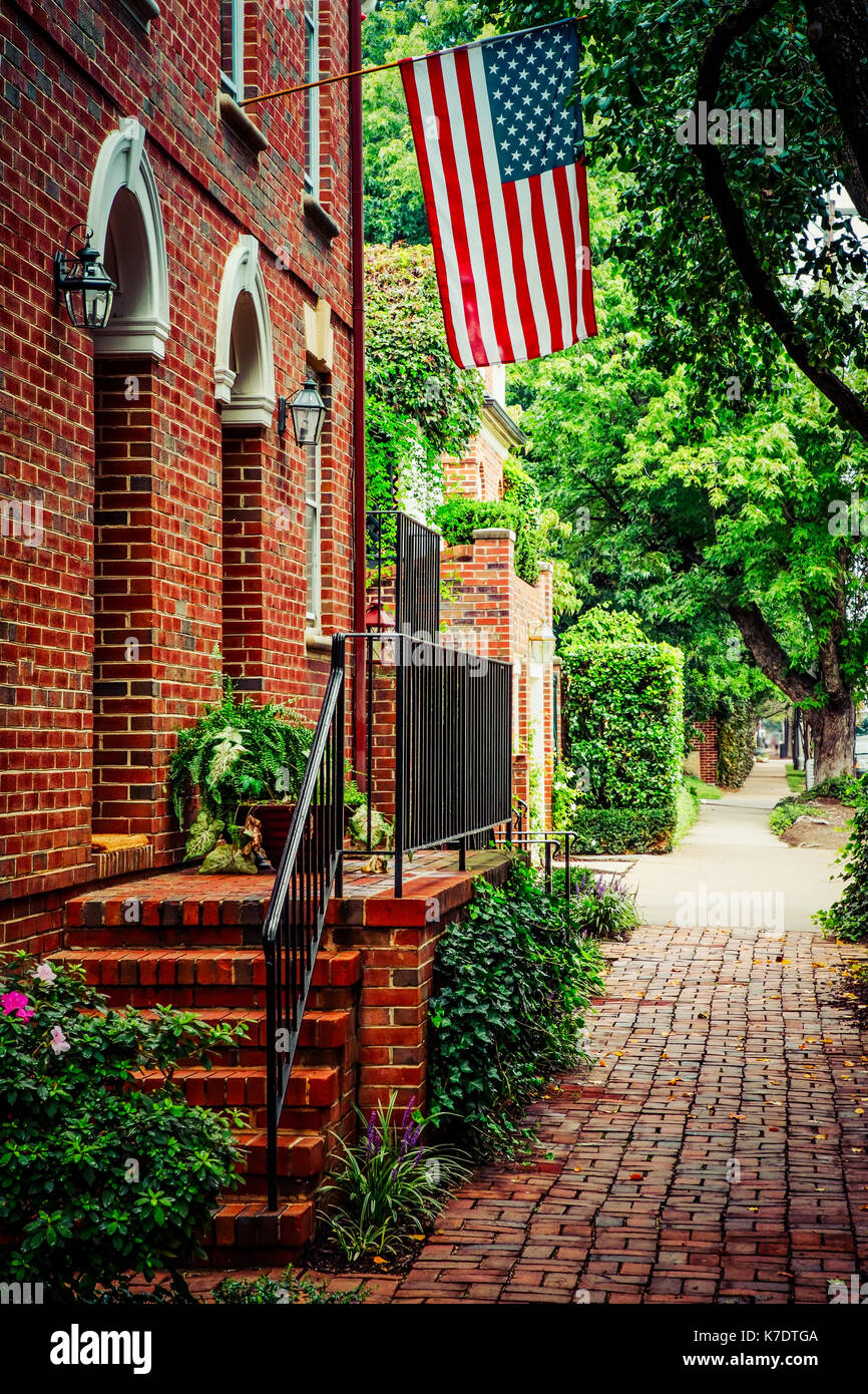 A flag flying over a Virginia street with cobblestone sidewalks and ...