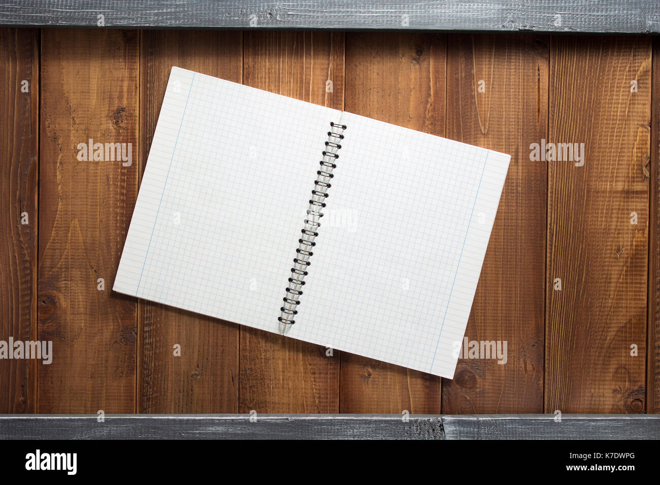 checked notebook at wooden background texture Stock Photo - Alamy