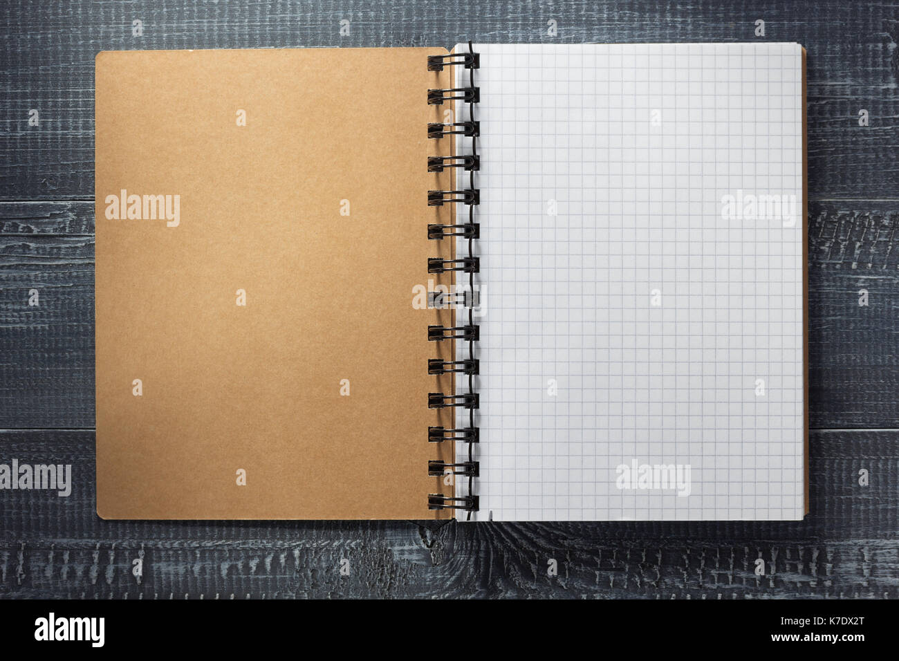 checked notebook at wooden background texture Stock Photo - Alamy
