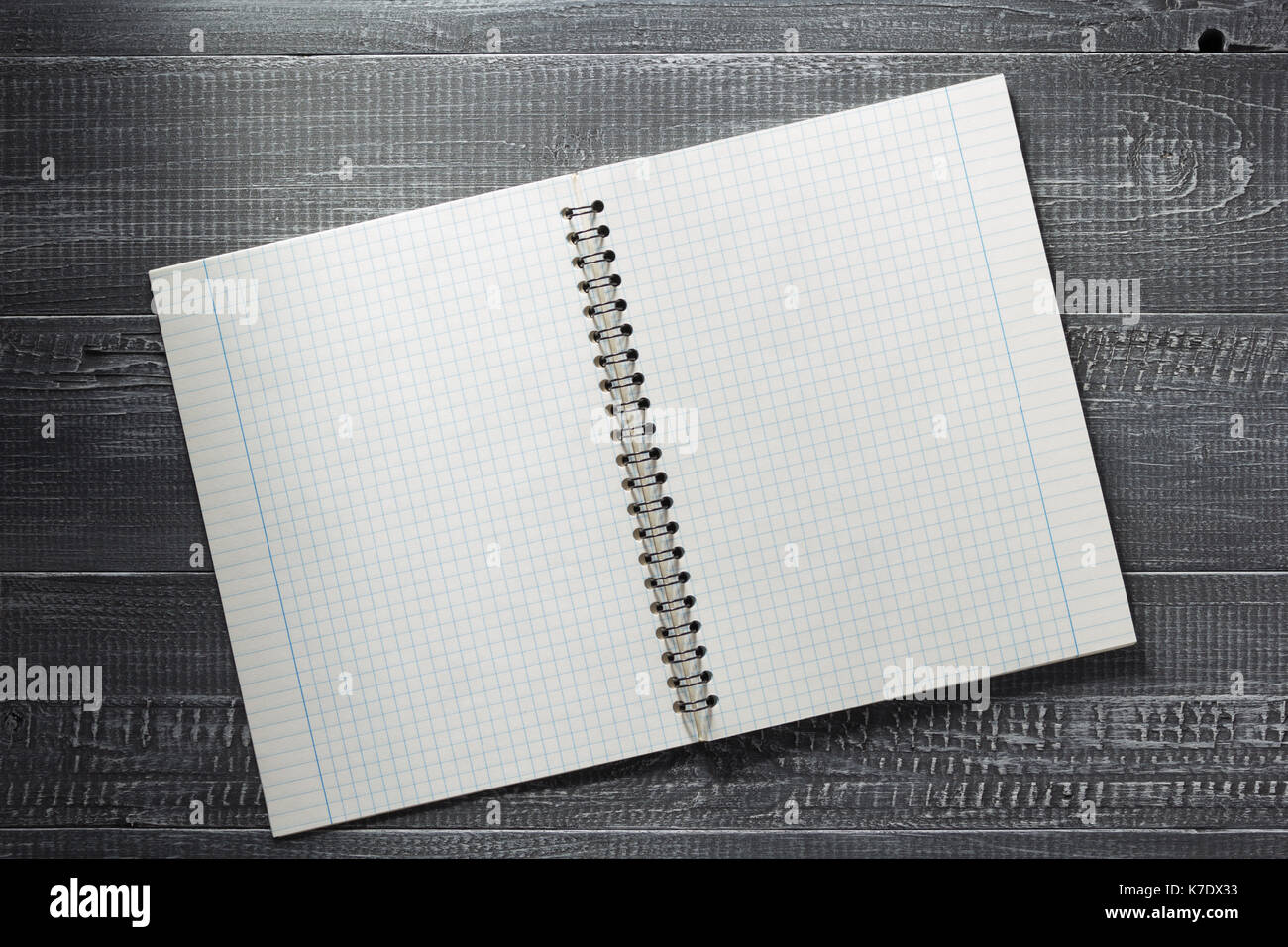 checked notebook at wooden background texture Stock Photo - Alamy