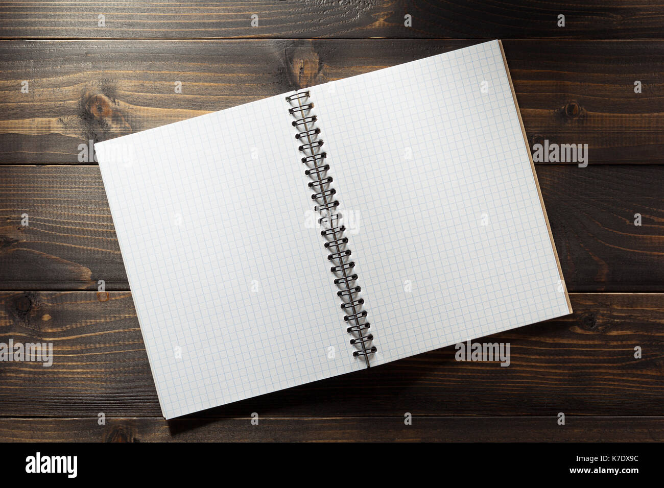 checked notebook at wooden background texture Stock Photo - Alamy