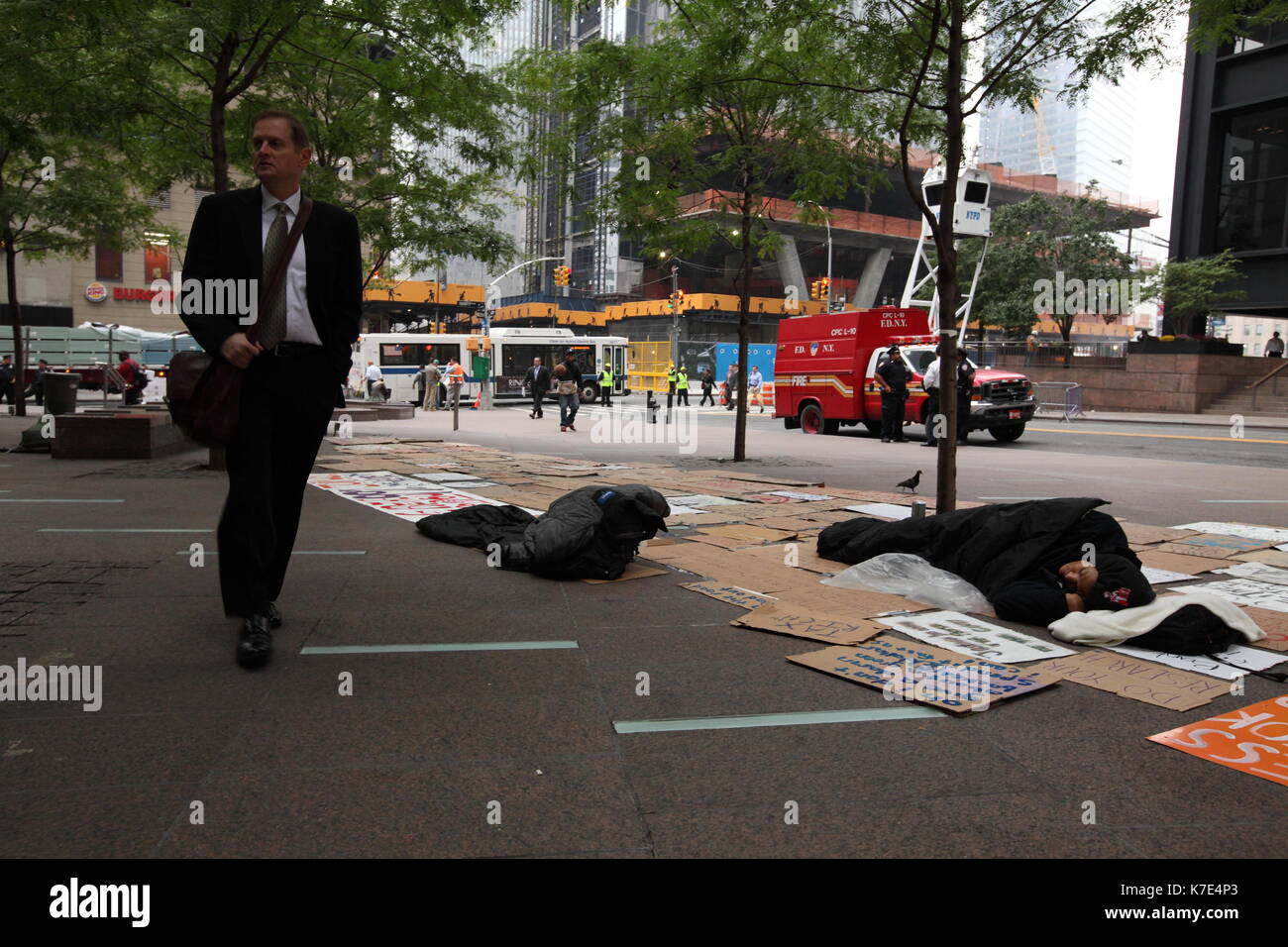 A businessman walks past sleeping supporters of the "Occupy Wall Street ...