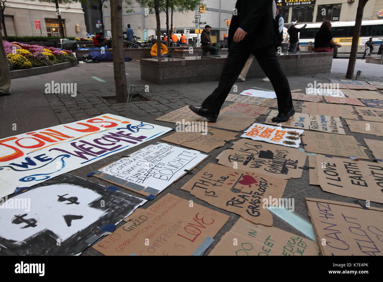 A businessman walks on protest signs at the "Occupy Wall Street ...