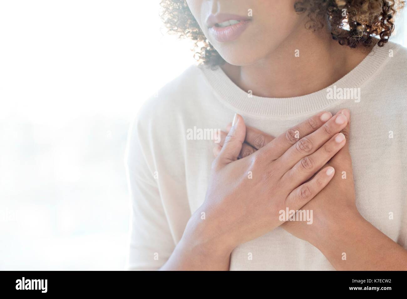Woman touching her chest hi-res stock photography and images - Alamy