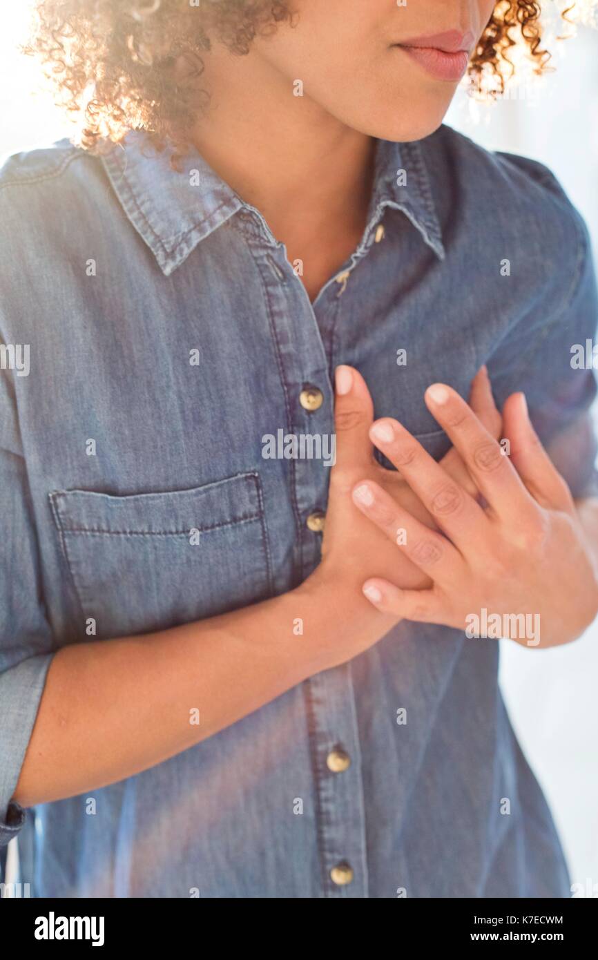 Woman touching breast Stock Photo - Alamy