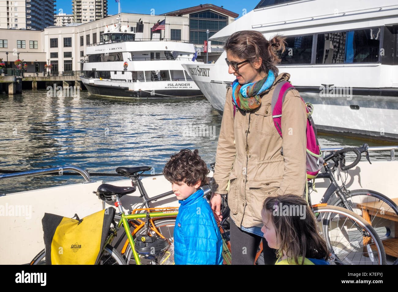 Family on a Berkeley ferry arrives in San Francisco. Mother with young ...