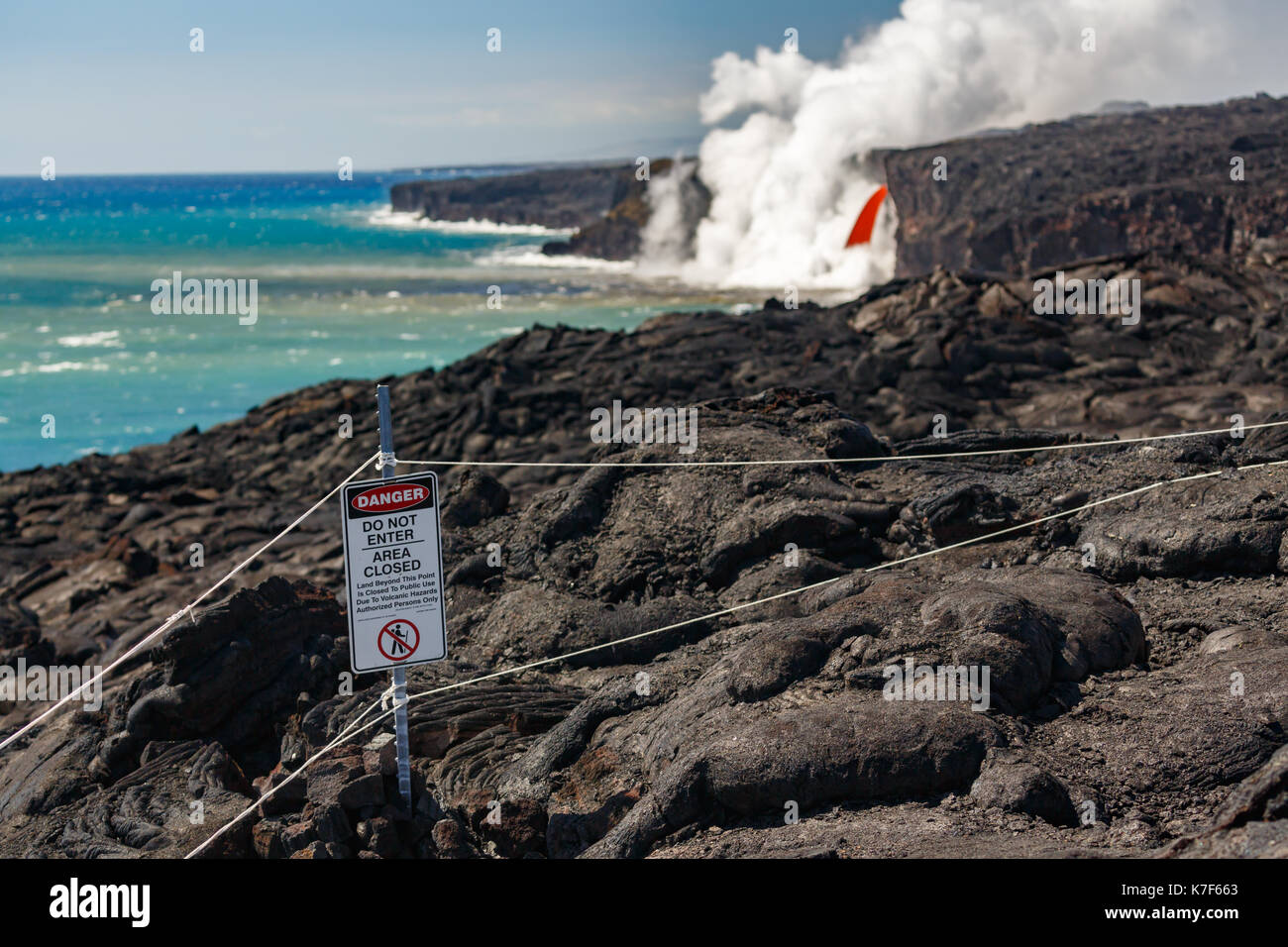 Danger sign marks safe viewing spot for bright red lava flow of volcano ...