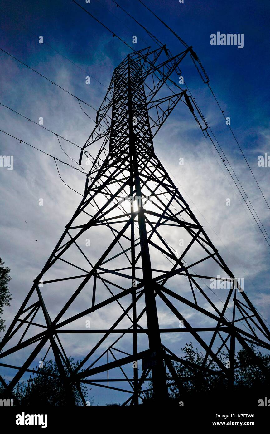 Oblique and upwards view of electrical tower backlit Stock Photo - Alamy