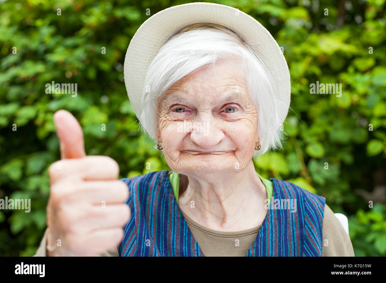 Elderly woman with mental disorder showing thumbs up in the park Stock ...