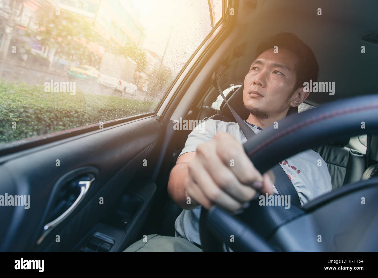 Asian man male drive a car and looking at the windows Stock Photo - Alamy