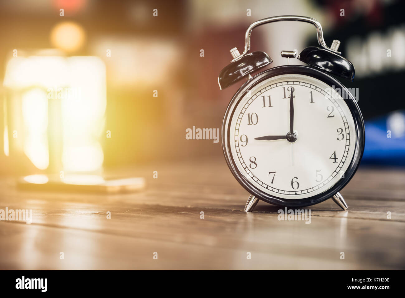 9 o'clock time retro clock on wood table with sun light background ...