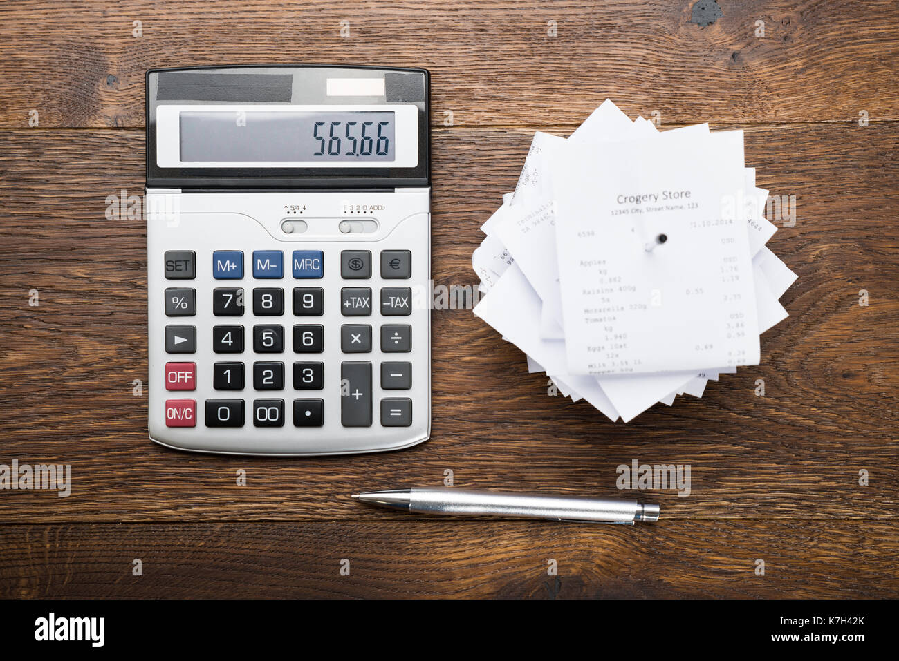 High Angle View Of Receipts With Calculator And Pen On Table Stock ...