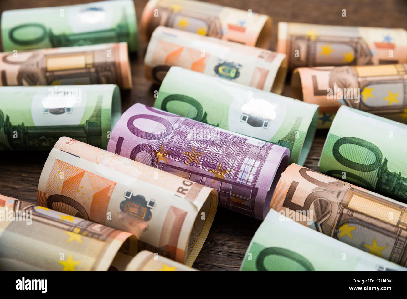 Close-up Of A Rolled Euro Banknotes On Wooden Desk Stock Photo - Alamy