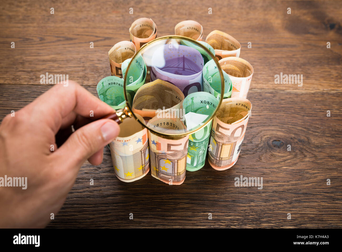 Close-up Of A Businessman's Hand Holding Magnifying Glass Over ...