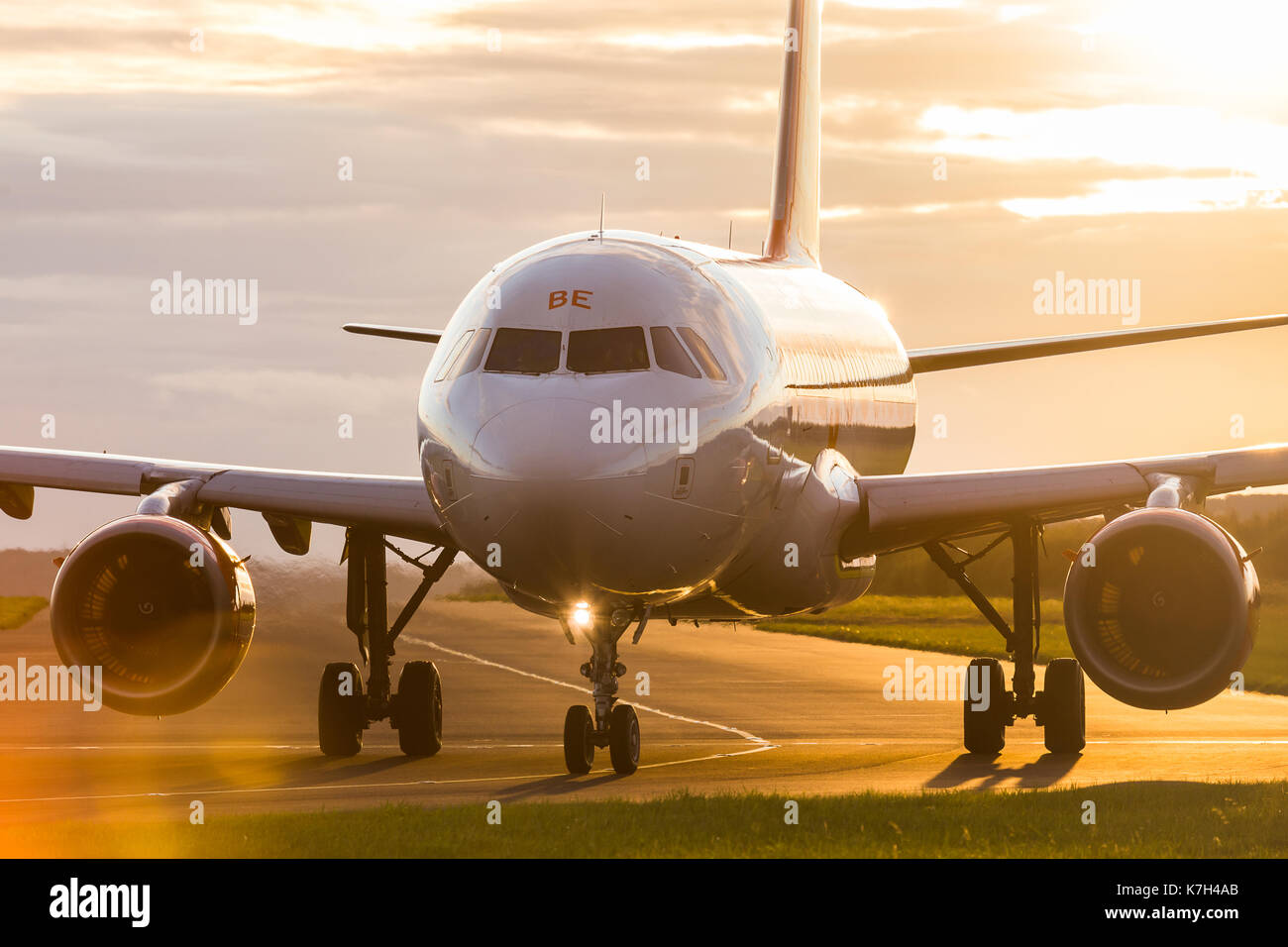 Backlit image taken at sunset of an Easyjet airliner taxiing out for ...