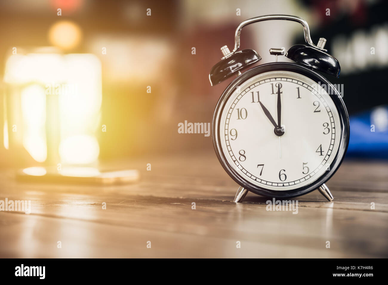 11 o'clock time retro clock on wood table with sun light background ...