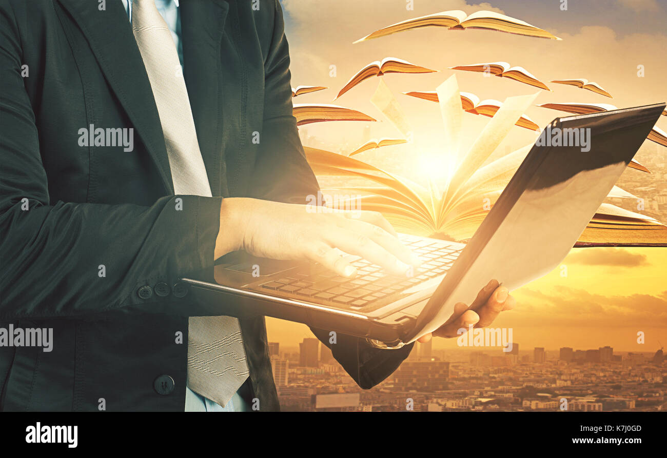 business man laying hand on computer laptop and khonwledge book flying ...