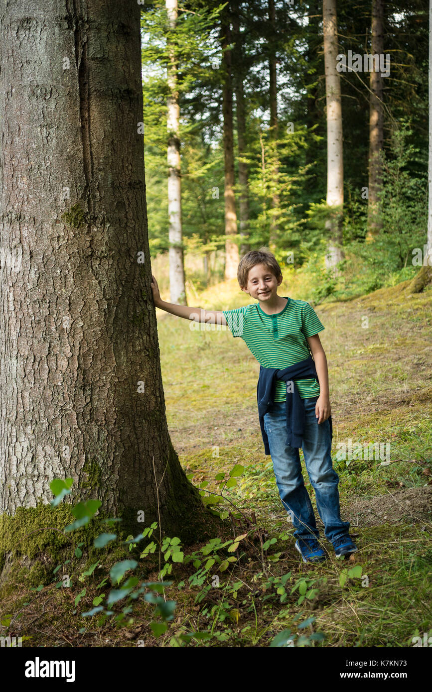 Boy leaning against tree hi-res stock photography and images - Alamy