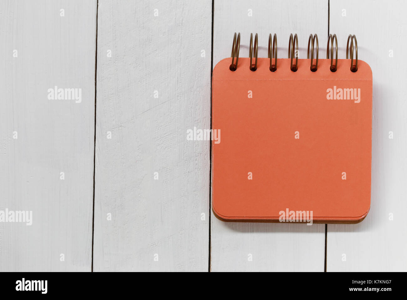 Empty orange notebook on white wooden floor and have copy space to ...