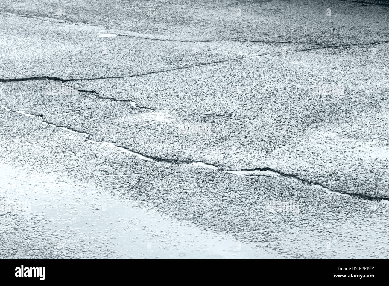 wet cracked asphalt road with paddle on it after heavy rain Stock Photo ...