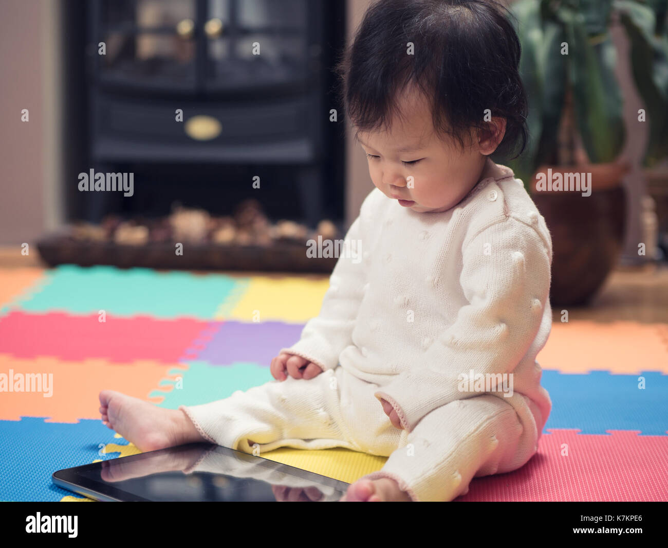 Adorable baby girl playing tablet at home Stock Photo - Alamy